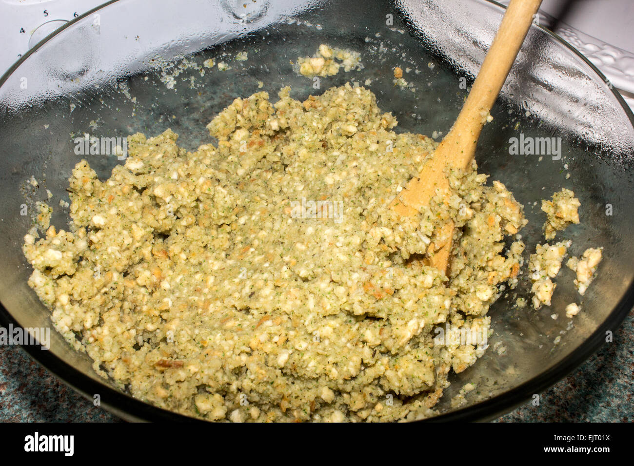 Stuffing mix with water in a glass bowl with a wooden spoon ready for ...