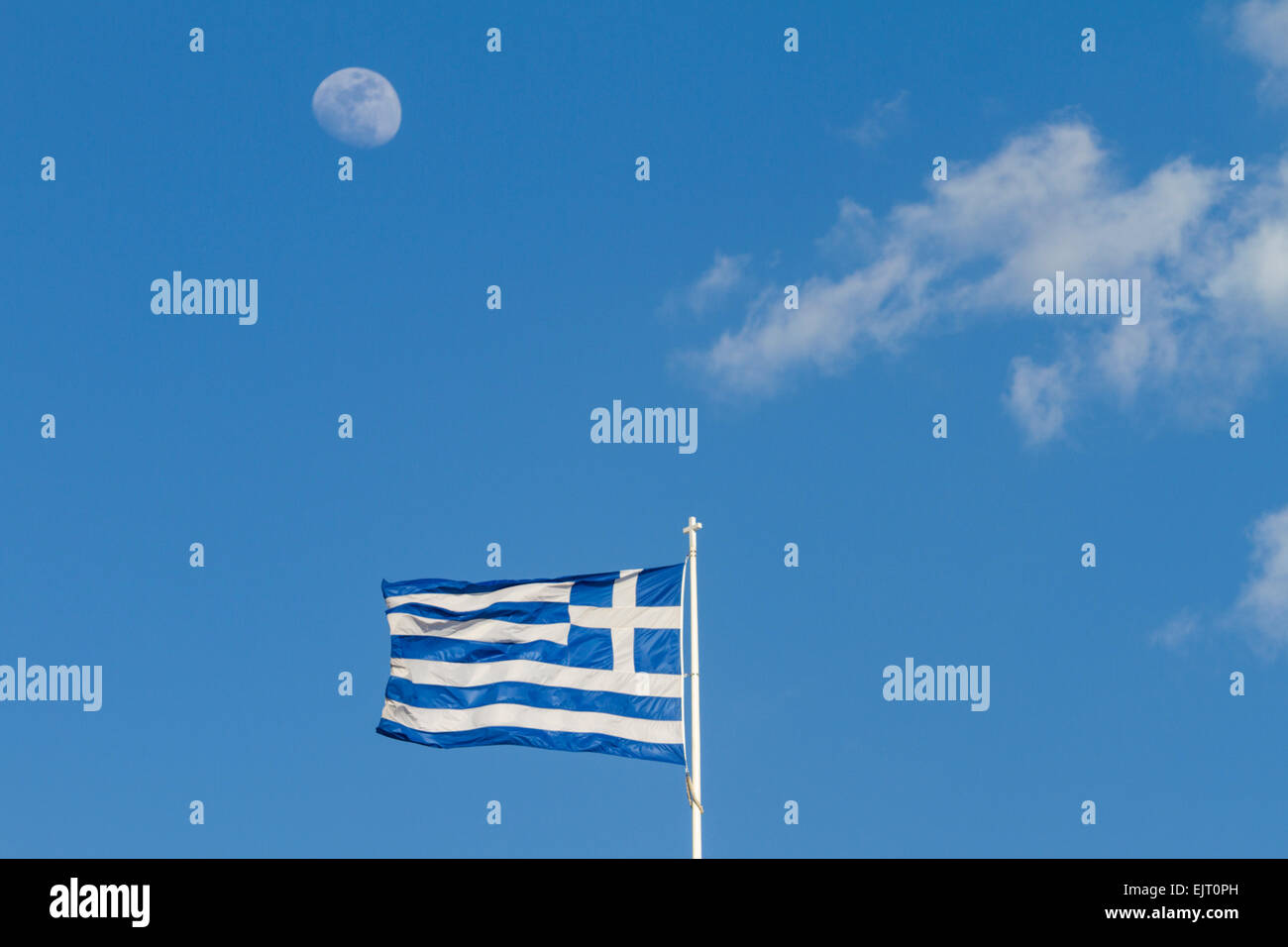 A waxing gibbous moon above a Greek flag that flies on a flagpole with ...