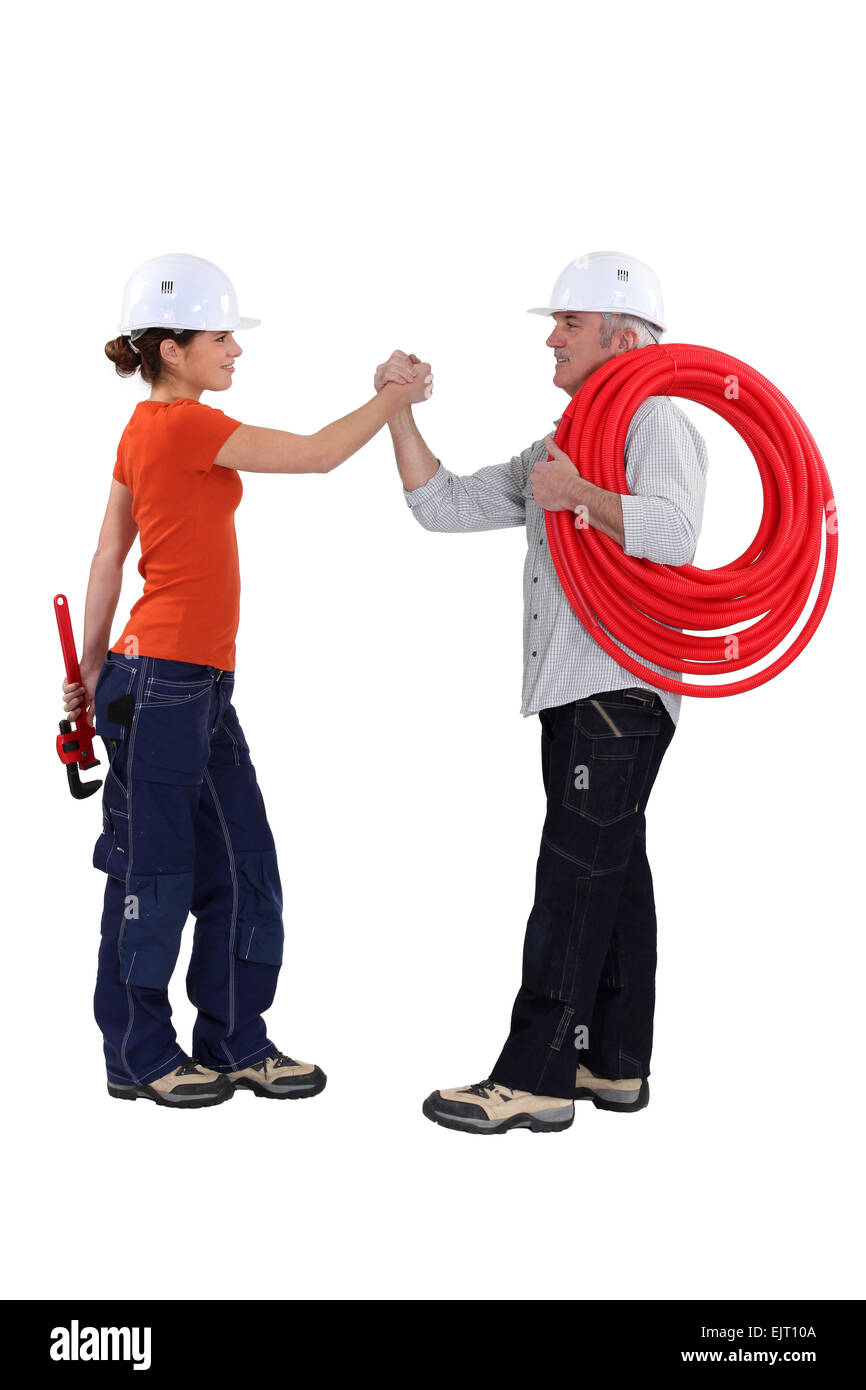Two handyman shaking hand Stock Photo - Alamy