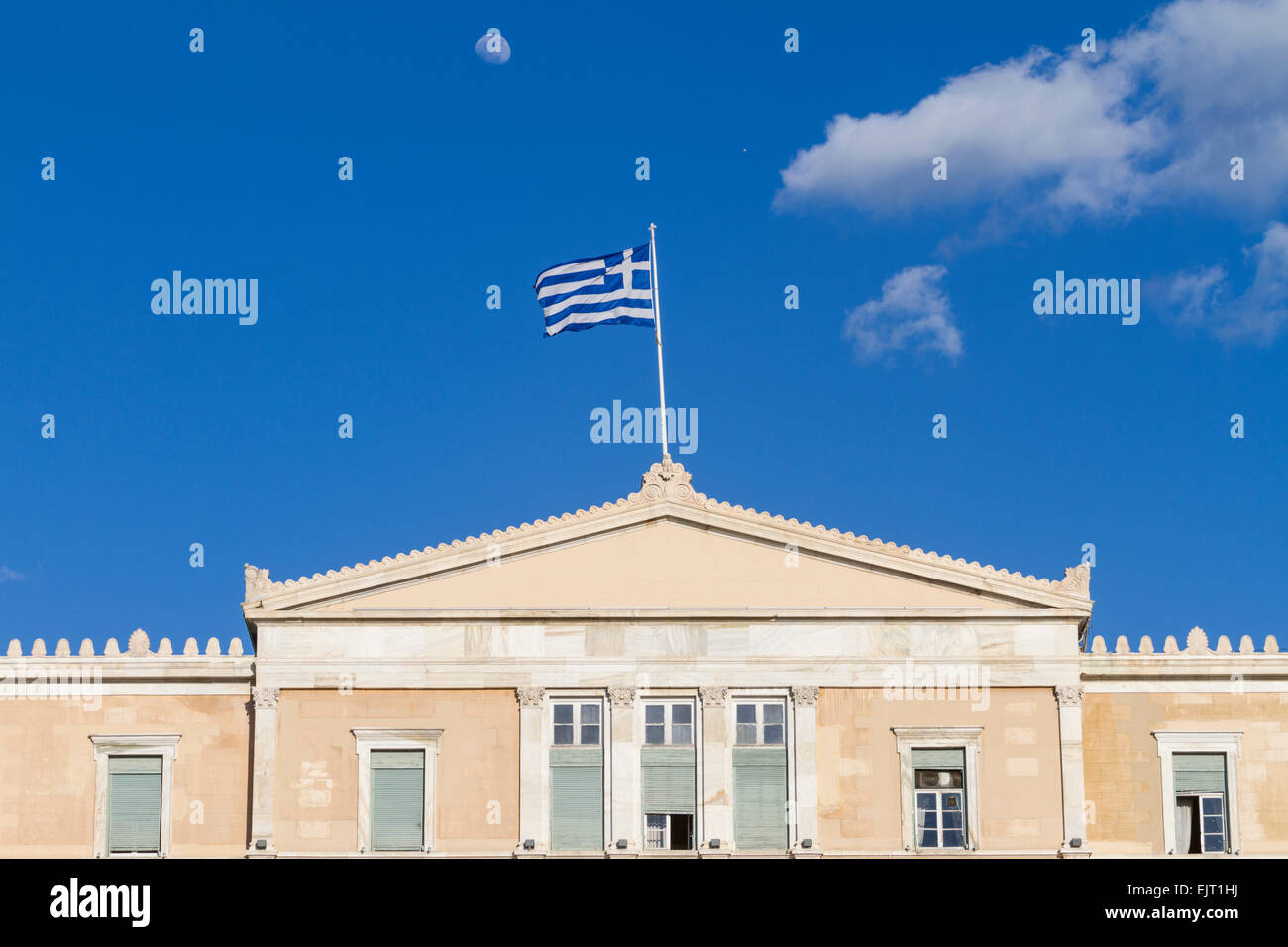 A waxing gibbous moon above a Greek flag that flies on a flag pole ...