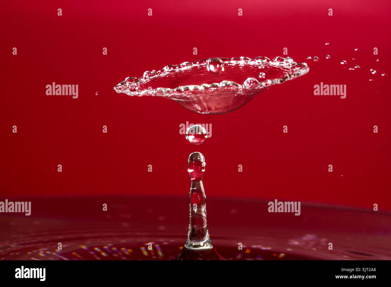 Water drop collisions with a red background Stock Photo - Alamy