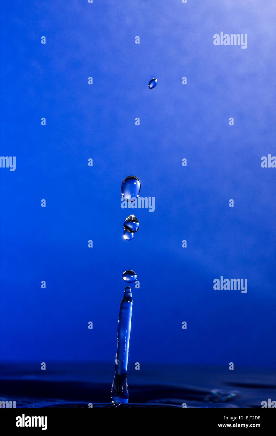 Water drop collisions with a blue background Stock Photo - Alamy
