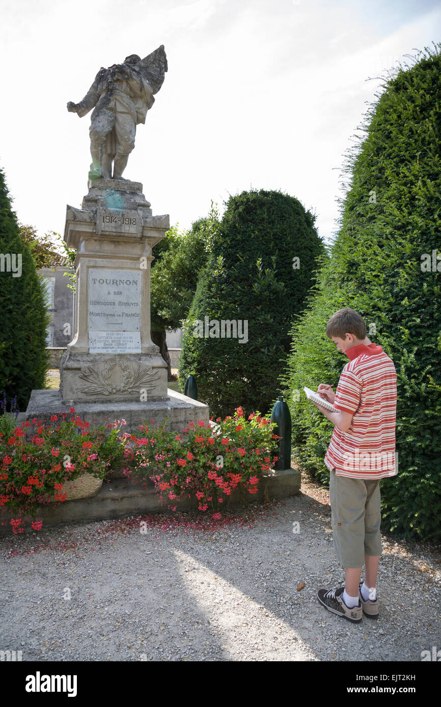 Young teenaged boy sketches a drawing of a WWI memorial in a park in ...