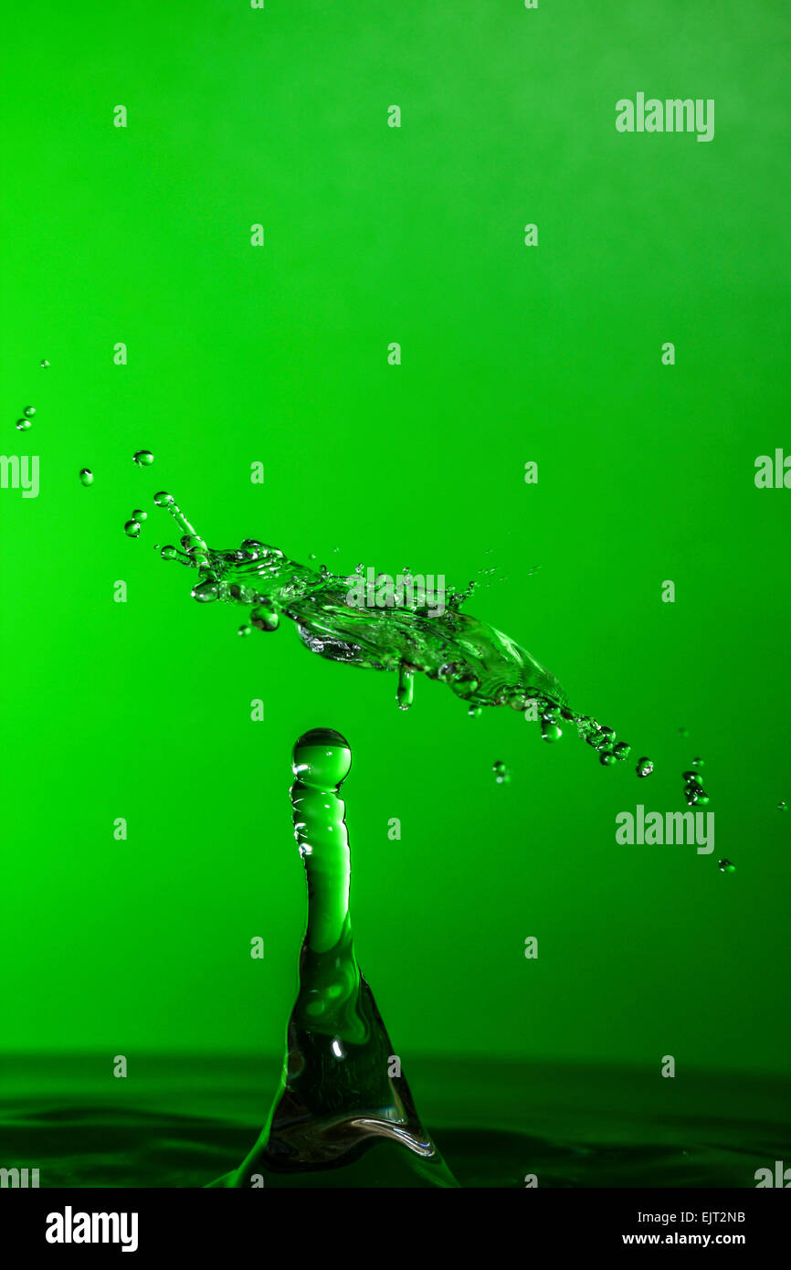 Water drop collisions with a green background Stock Photo - Alamy