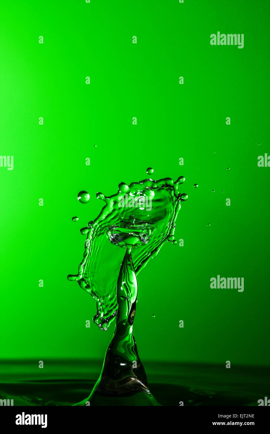 Water drop collisions with a green background Stock Photo - Alamy