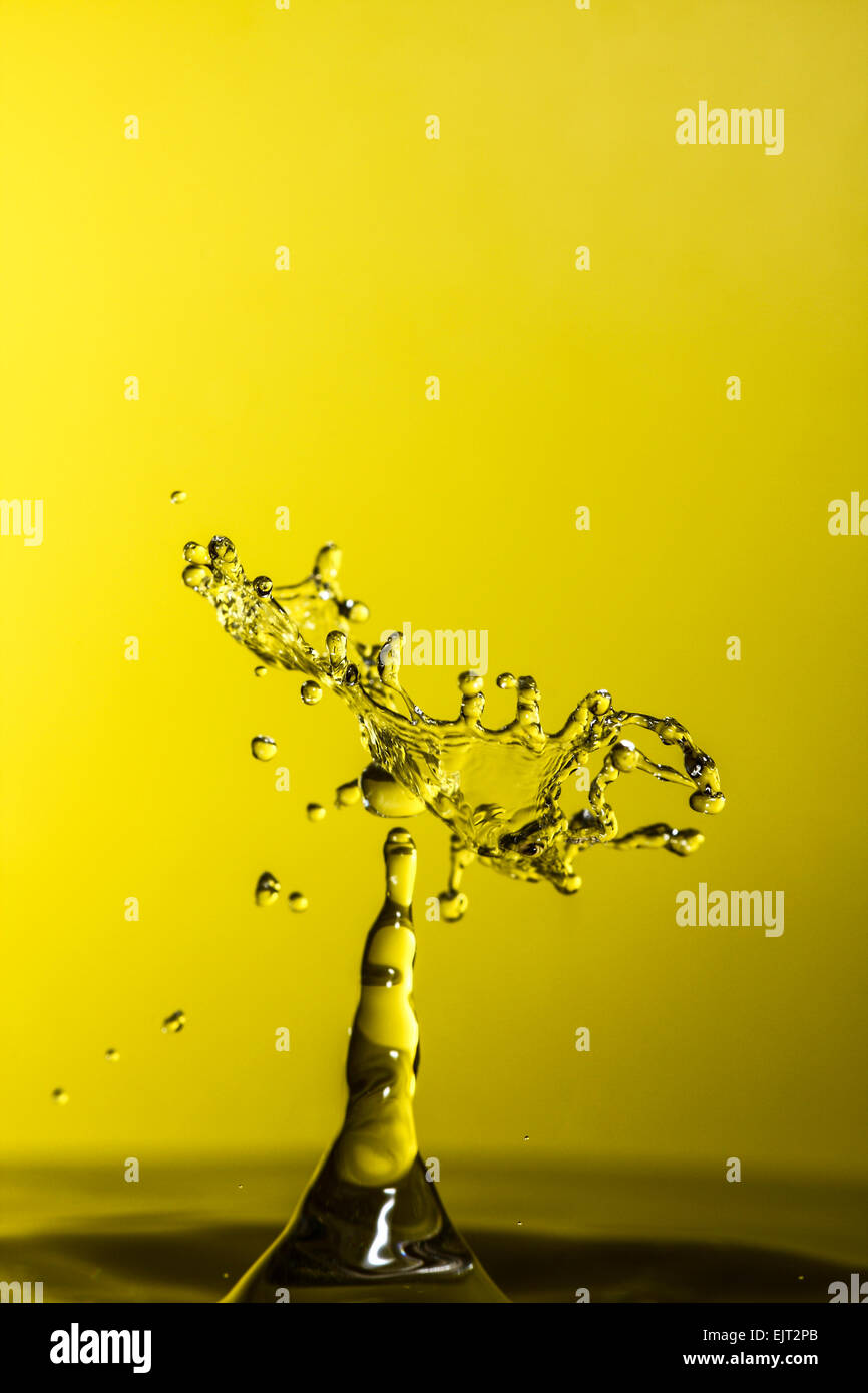 Water drop collisions with a yellow background Stock Photo - Alamy
