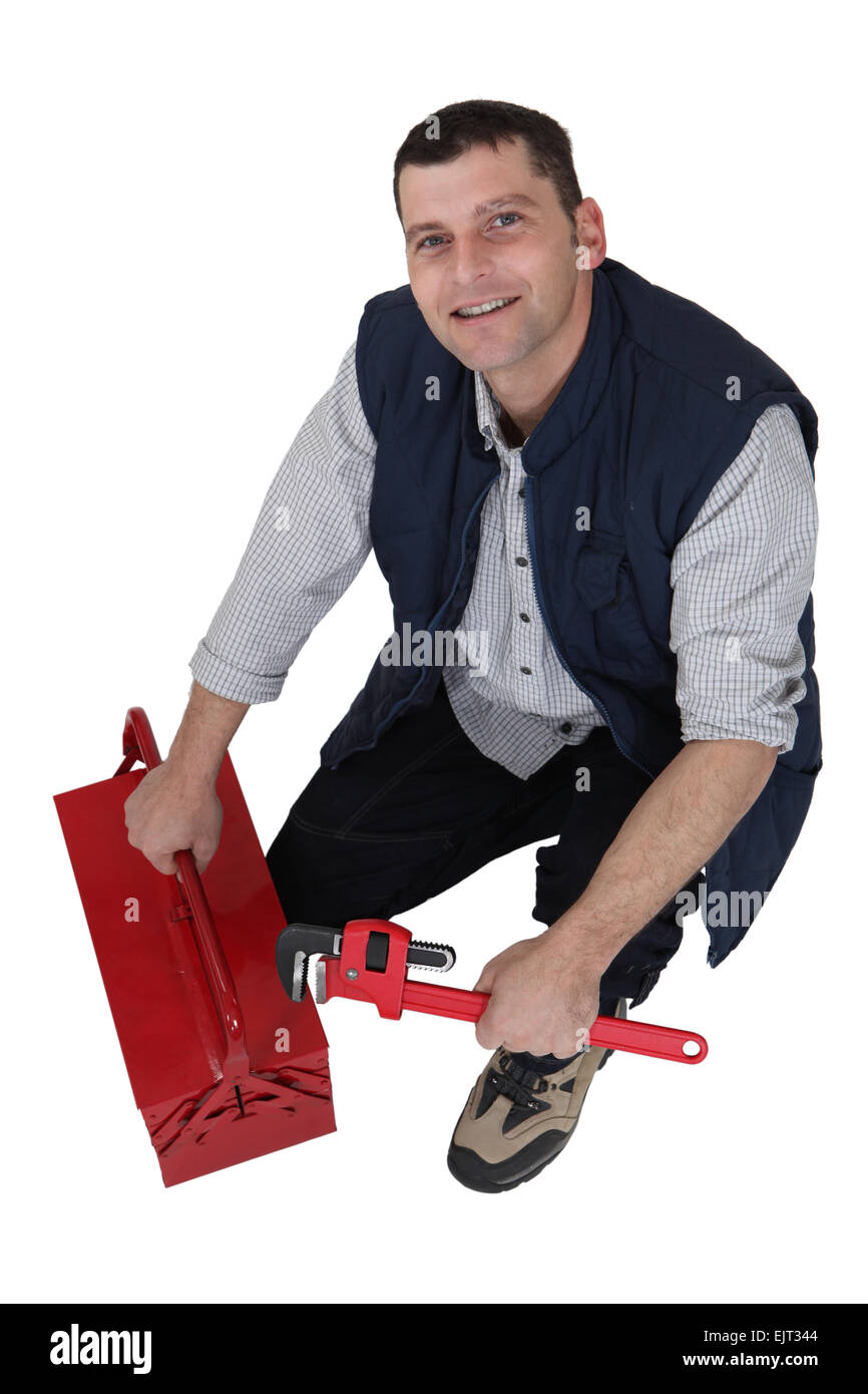 Plumber kneeling next to tool kit Stock Photo - Alamy