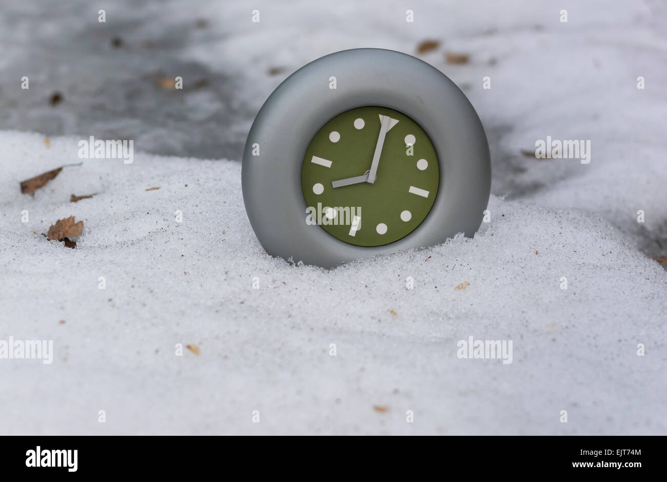 Clock on the snow Stock Photo - Alamy