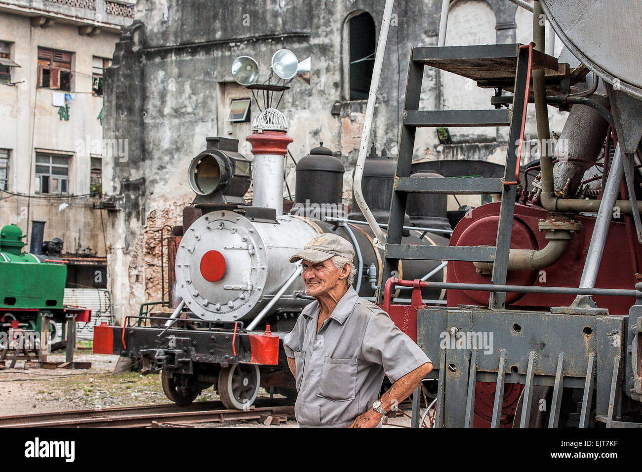 Worker standing in front of old American steam trains being restored in ...