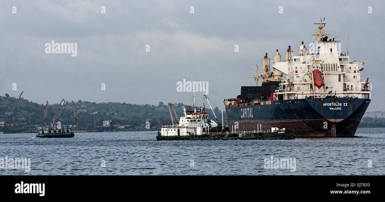 Oil tanker with support boat and ferry in the distance in the harbour ...