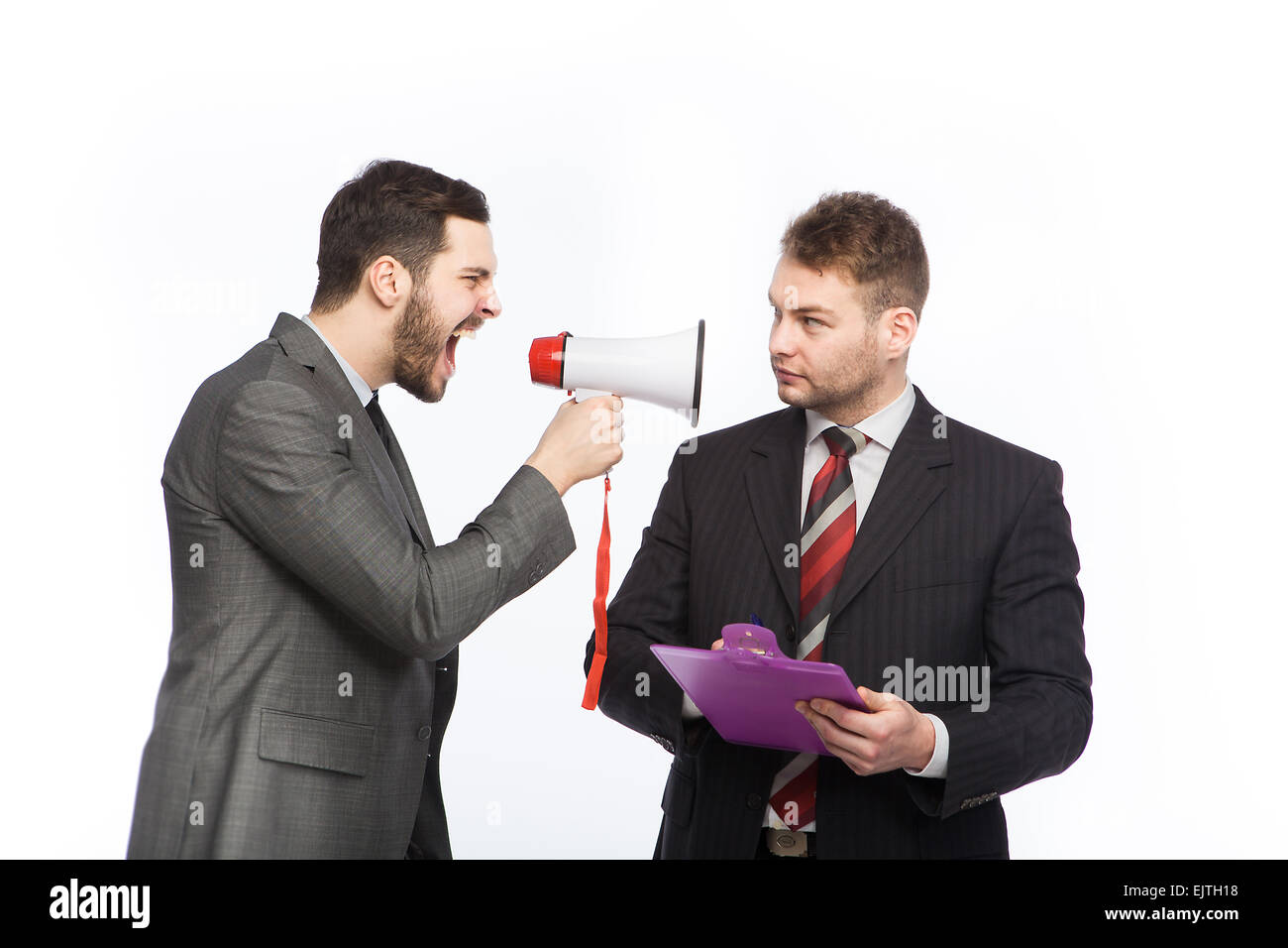 Businessman yelling through a megaphone at a colleague who has a ...