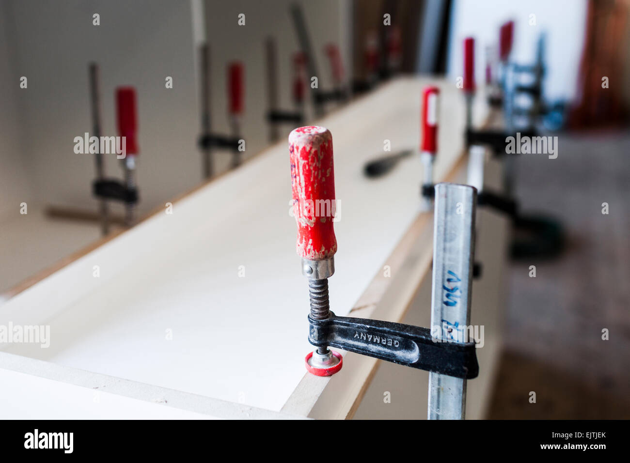Clamps attached on plank in workshop Stock Photo - Alamy