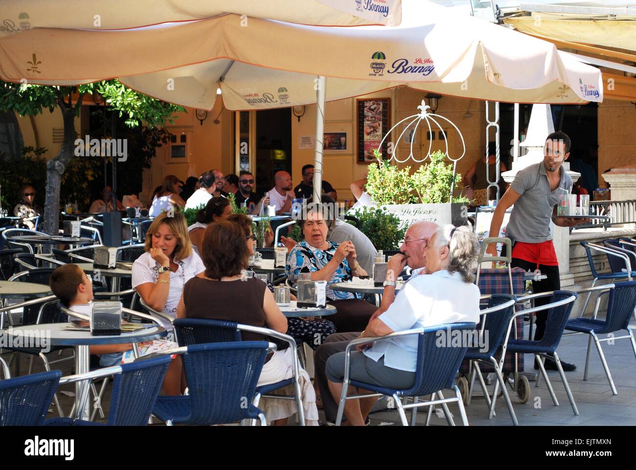Spanish people relaxing at a pavement cafe in the Plaza del Cabildo ...