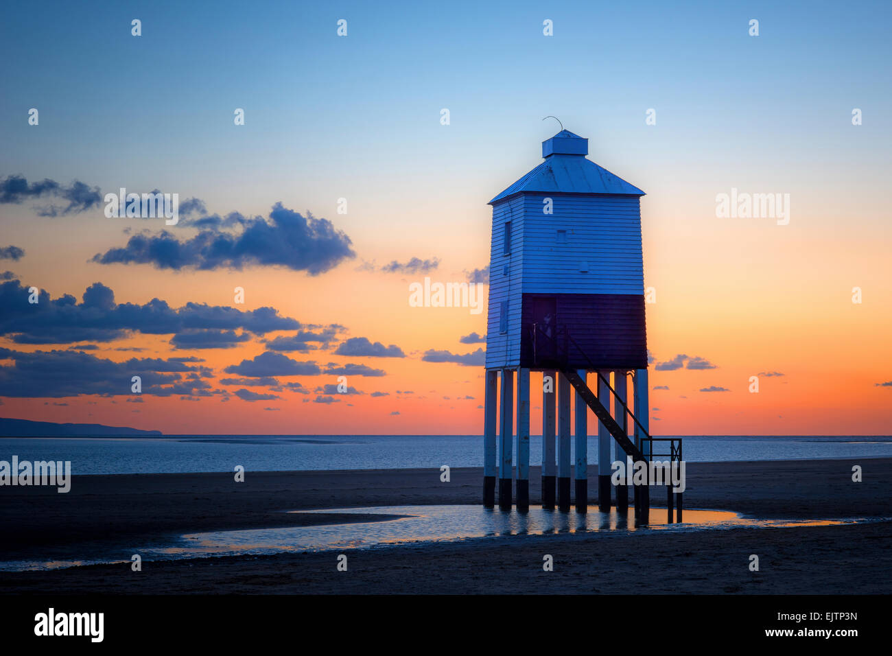 PIllar lighthouse on beach at sunset Stock Photo - Alamy
