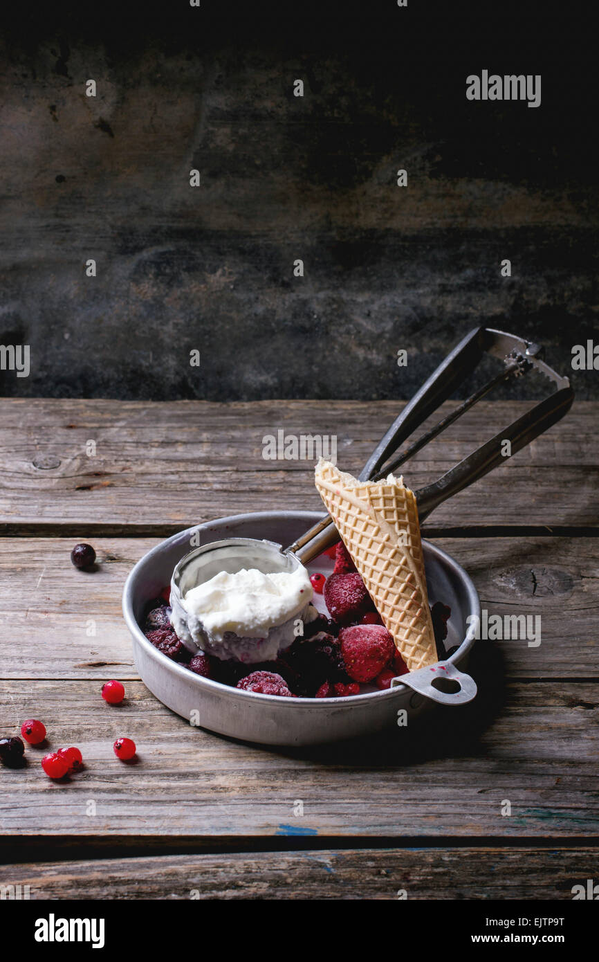 Aluminium plate with vanilla ice cream, mix of frozen berries and ...