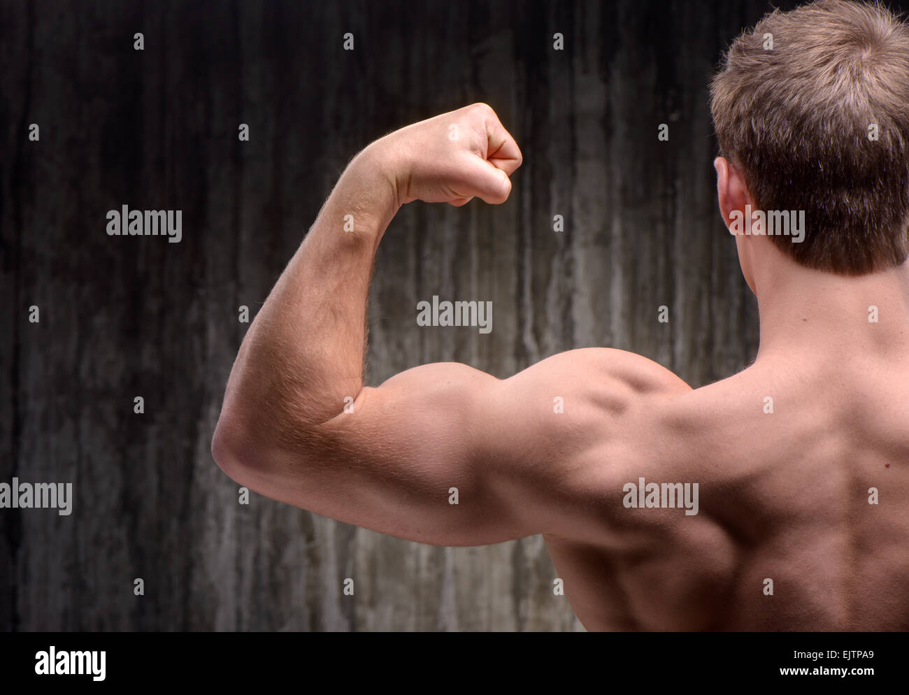 Back view of well formed man demonstrating biceps Stock Photo - Alamy