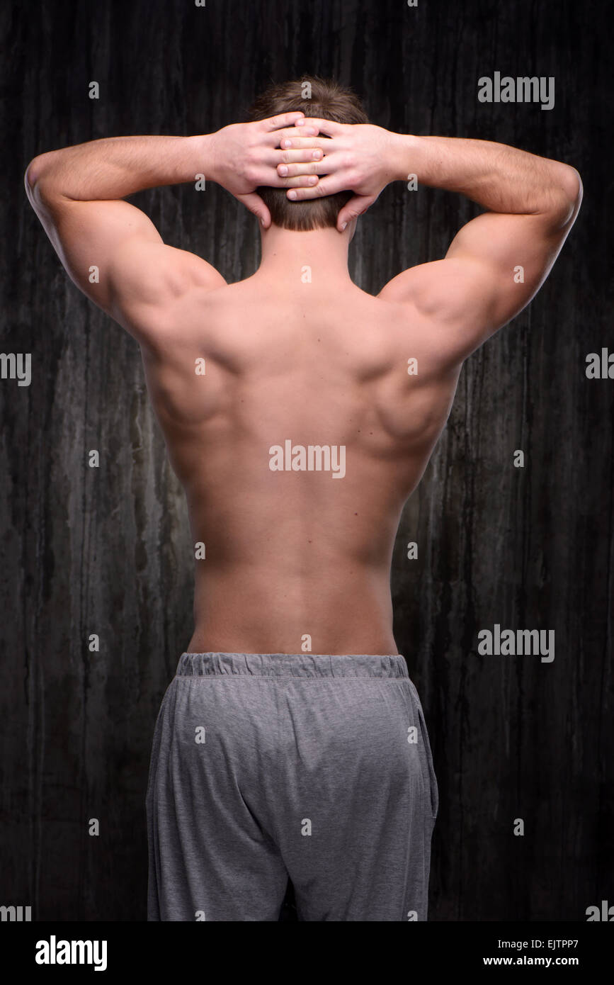 Back view of well formed man demonstrating back muscles Stock Photo - Alamy
