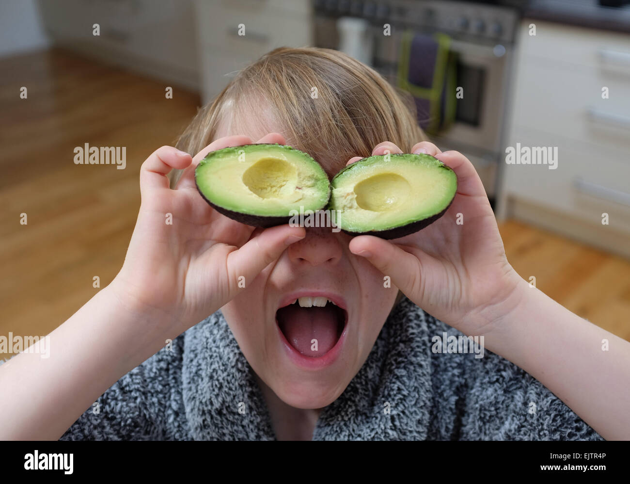 A boy holding an avocado over his eyes Stock Photo - Alamy
