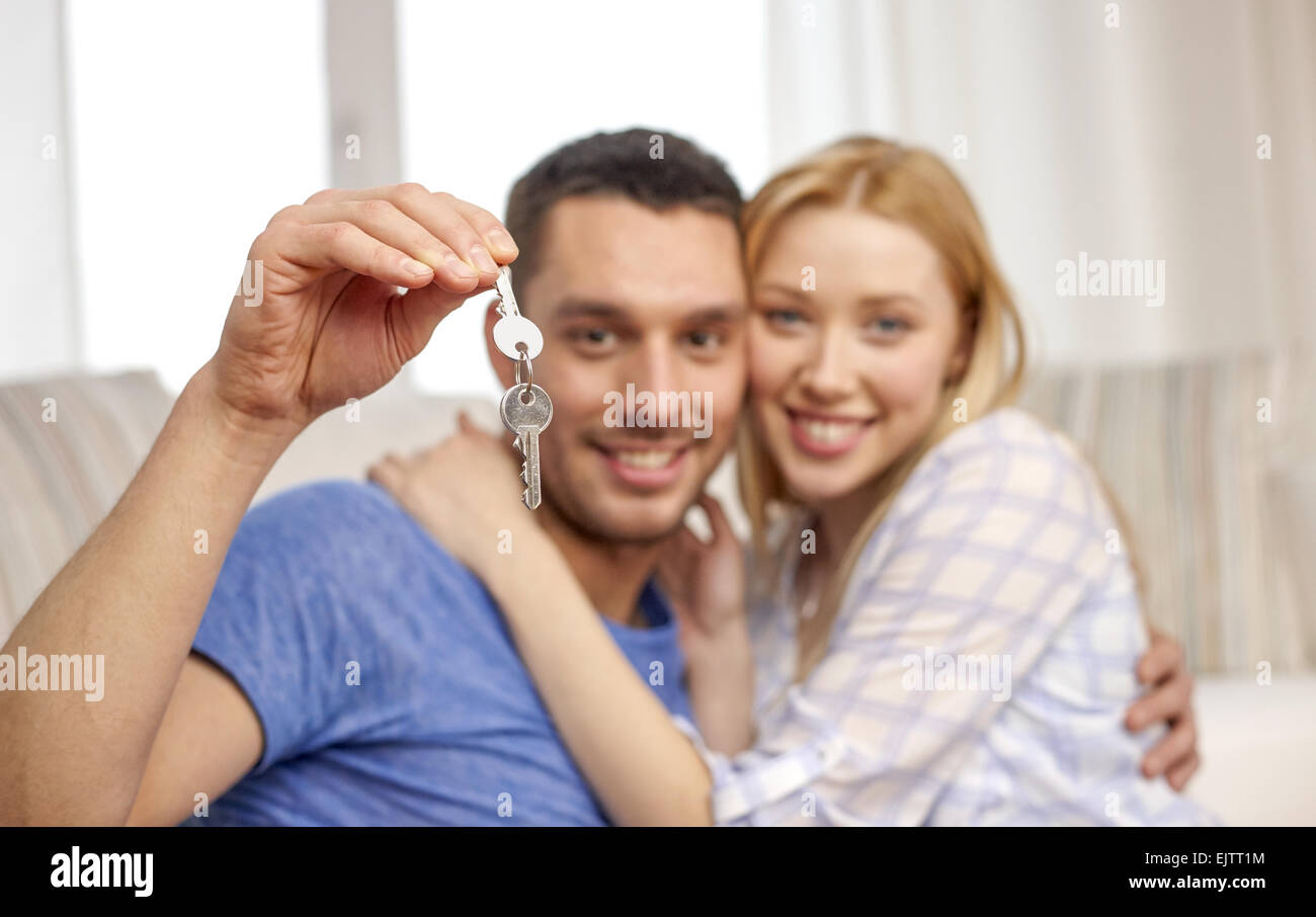 smiling couple showing keys over room background Stock Photo - Alamy