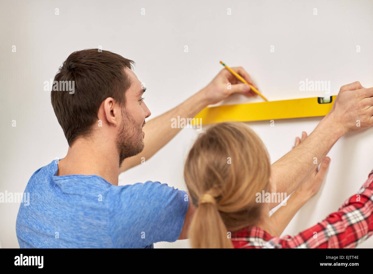 close up of couple with level measuring wall Stock Photo - Alamy