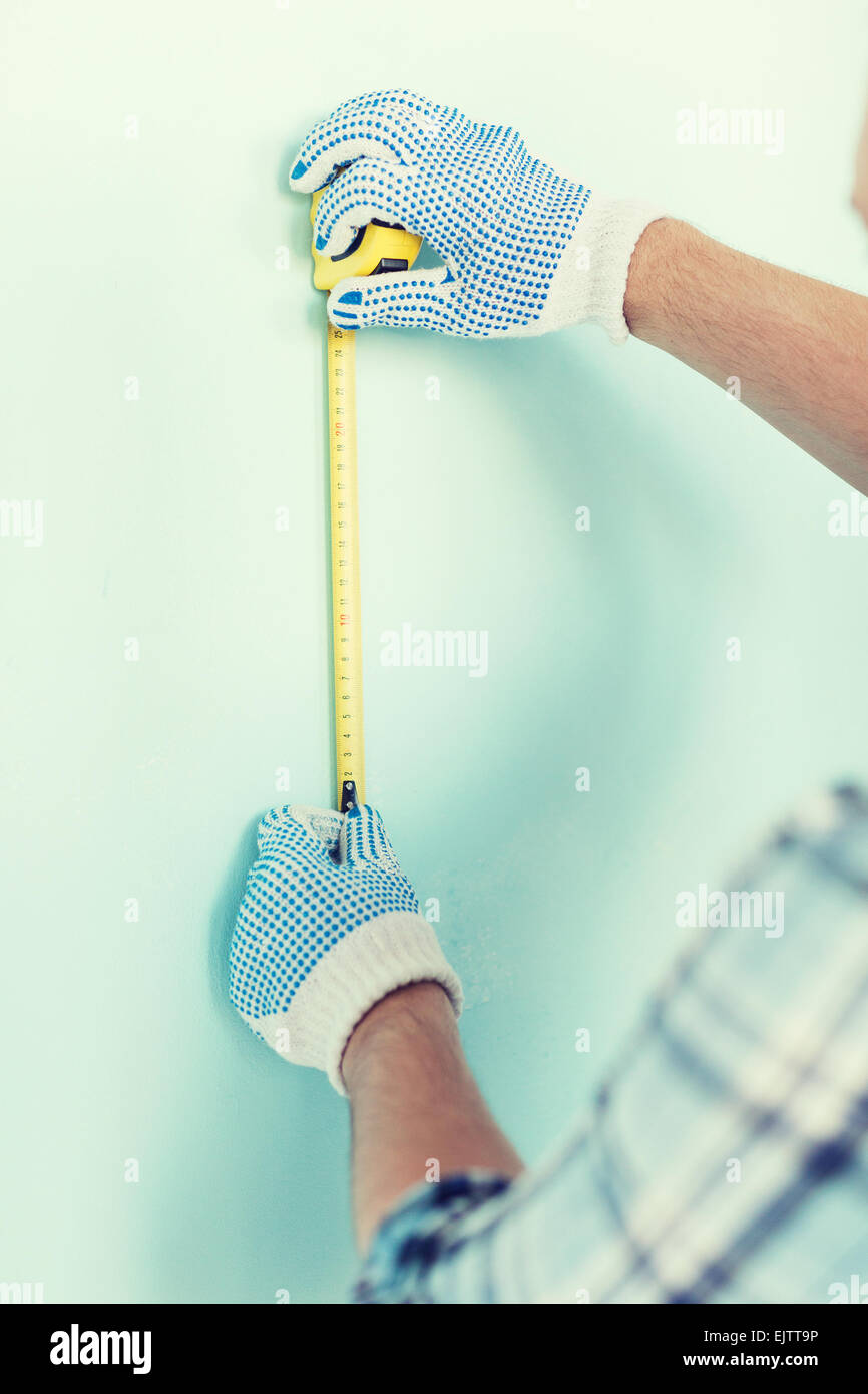 closeup of male in gloves measuring wall with tape Stock Photo - Alamy
