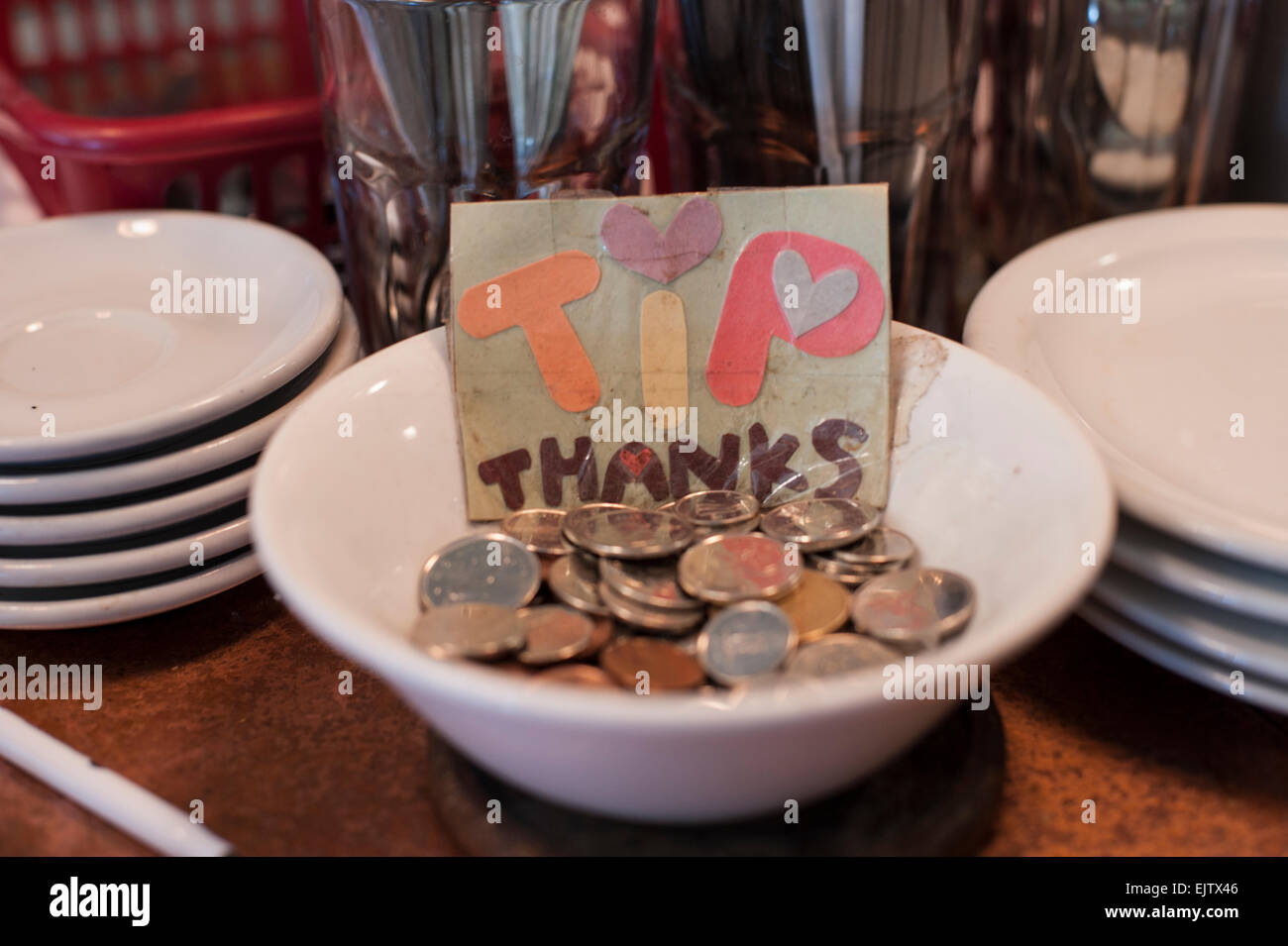 A tip jar, with heart designs on the words "tips, thanks" on the ...
