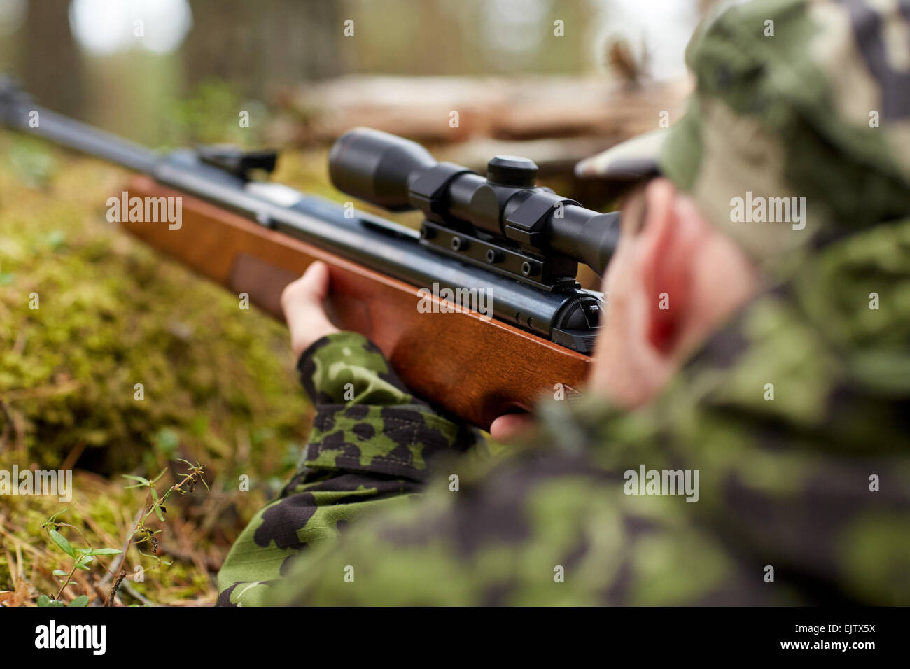 soldier or hunter shooting with gun in forest Stock Photo - Alamy