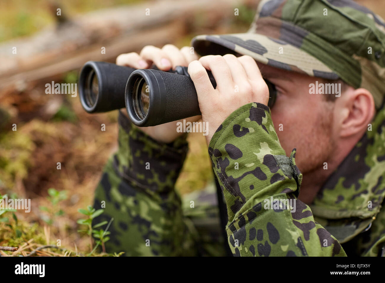 young soldier or hunter with binocular in forest Stock Photo - Alamy