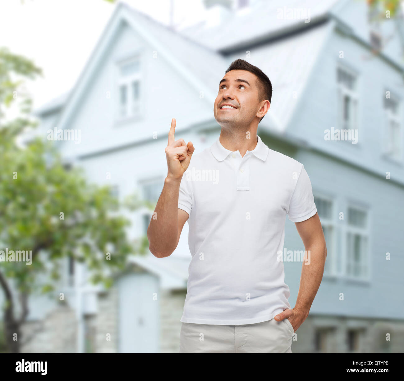 man pointing finger up over house background Stock Photo - Alamy