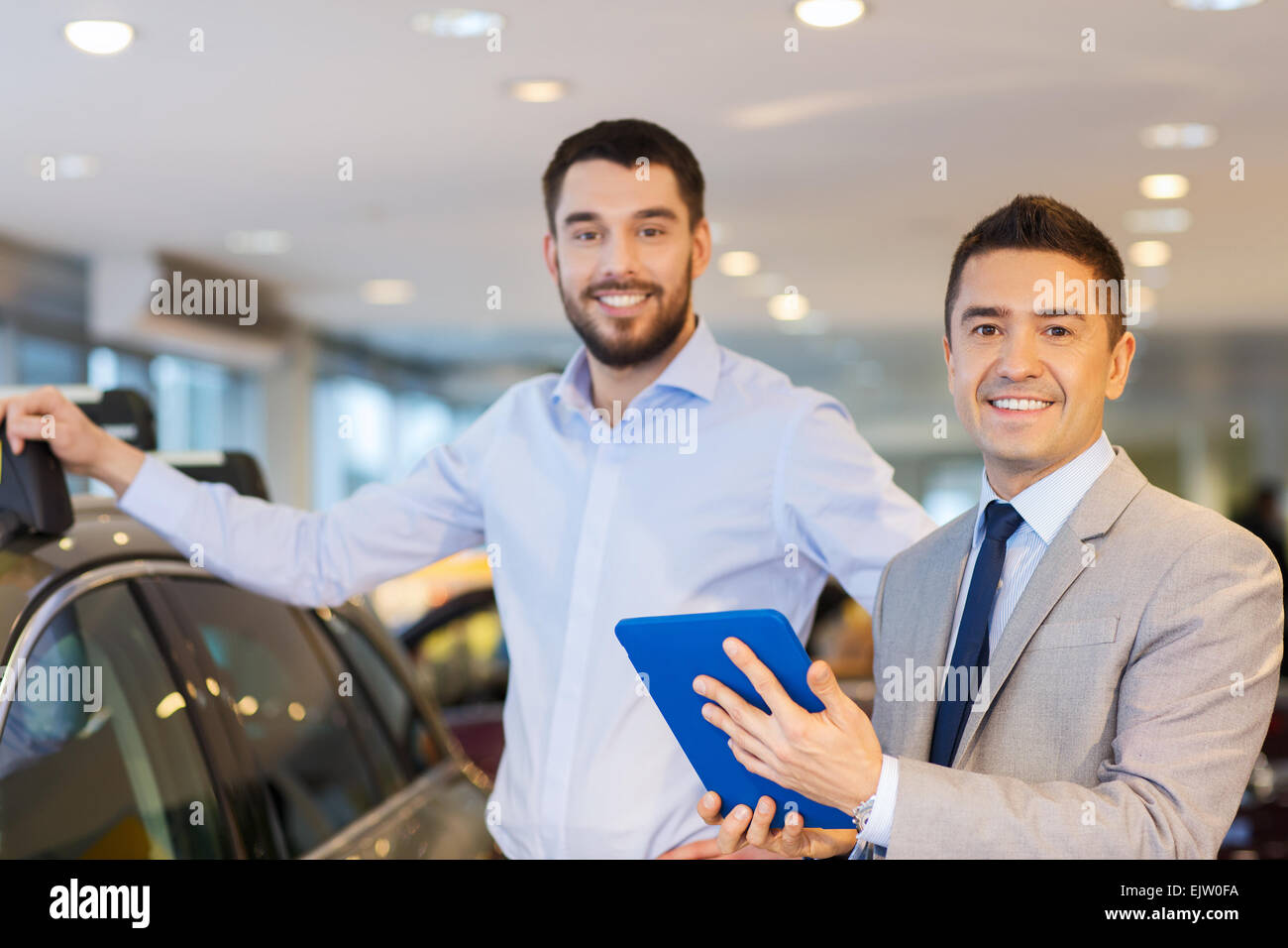 happy man with car dealer in auto show or salon Stock Photo - Alamy