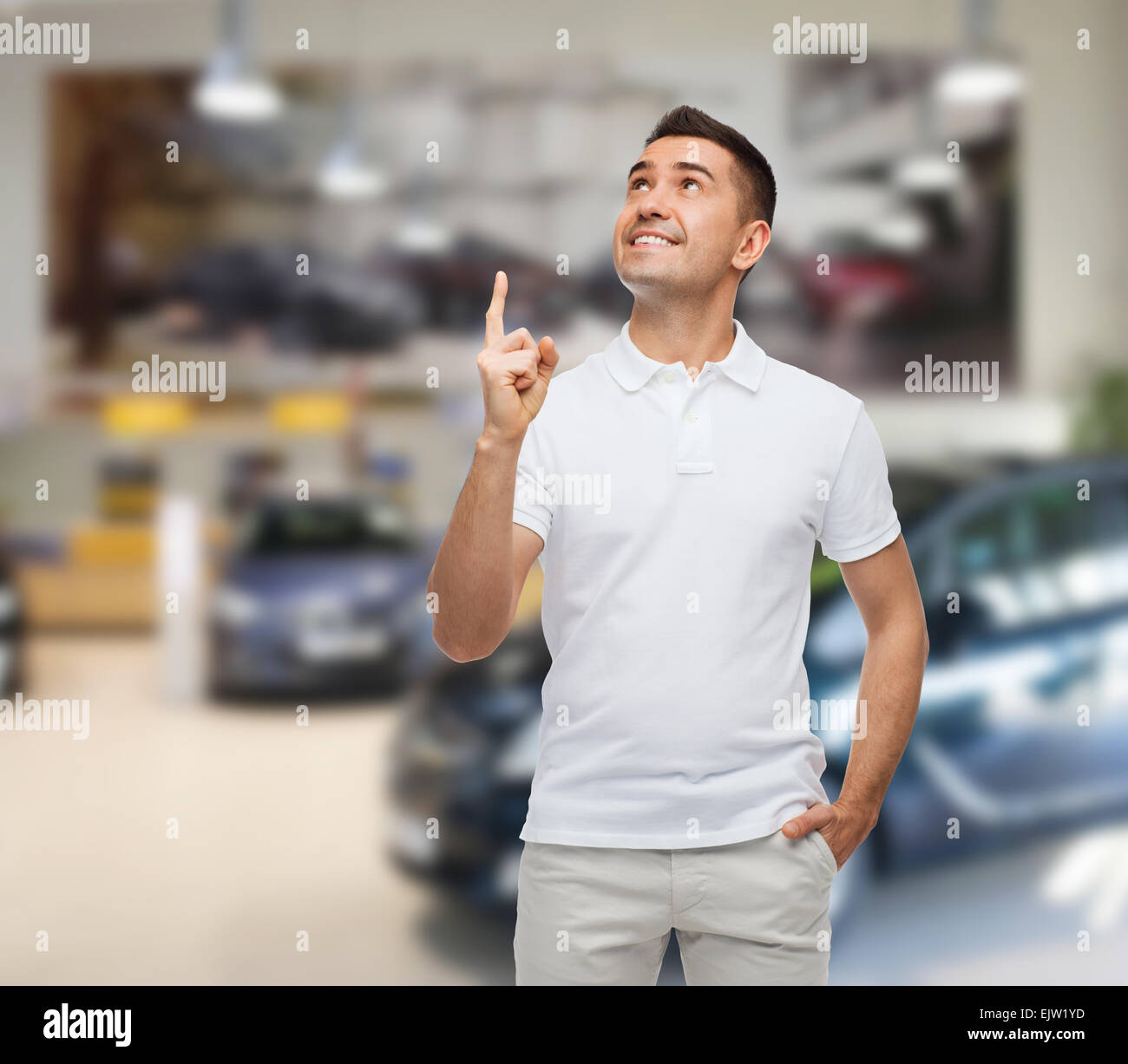 smiling man pointing finger up over auto show Stock Photo - Alamy
