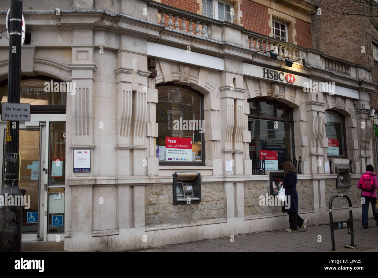 Woman using an ATM machine at an HSBC branch on Lordship Lane, East ...
