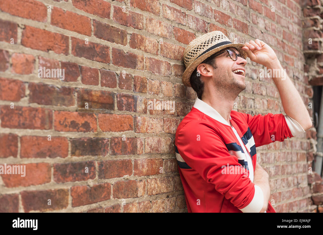 Portrait of mid adult man in front of brick wall Stock Photo - Alamy