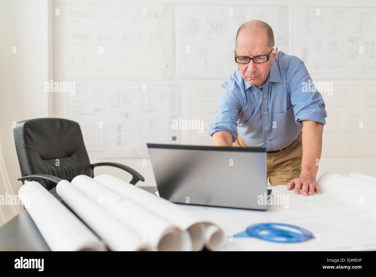 Mature architect using laptop in office Stock Photo - Alamy