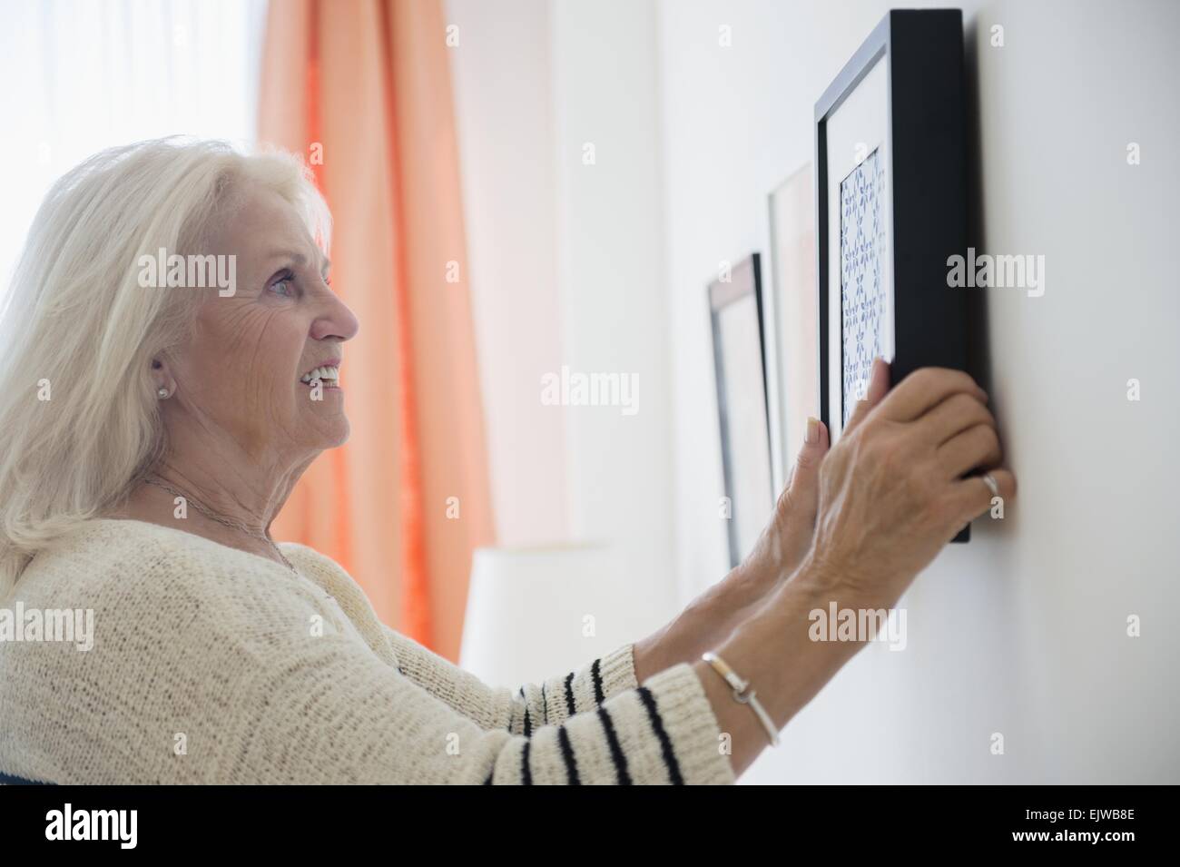 Woman Hanging Frame On The Wall High Resolution Stock Photography and ...