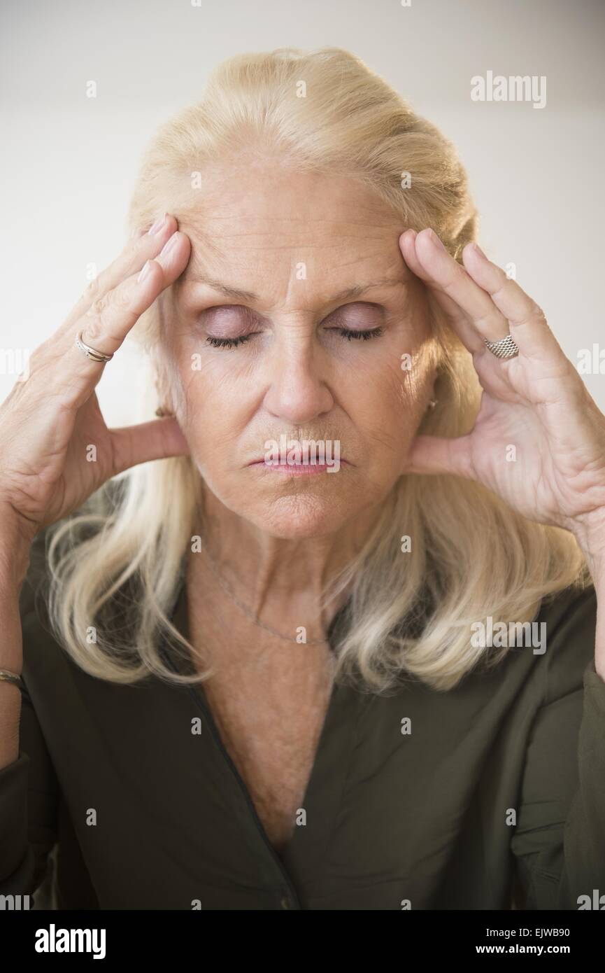 Portrait of senior woman holding head, eyes closed Stock Photo - Alamy