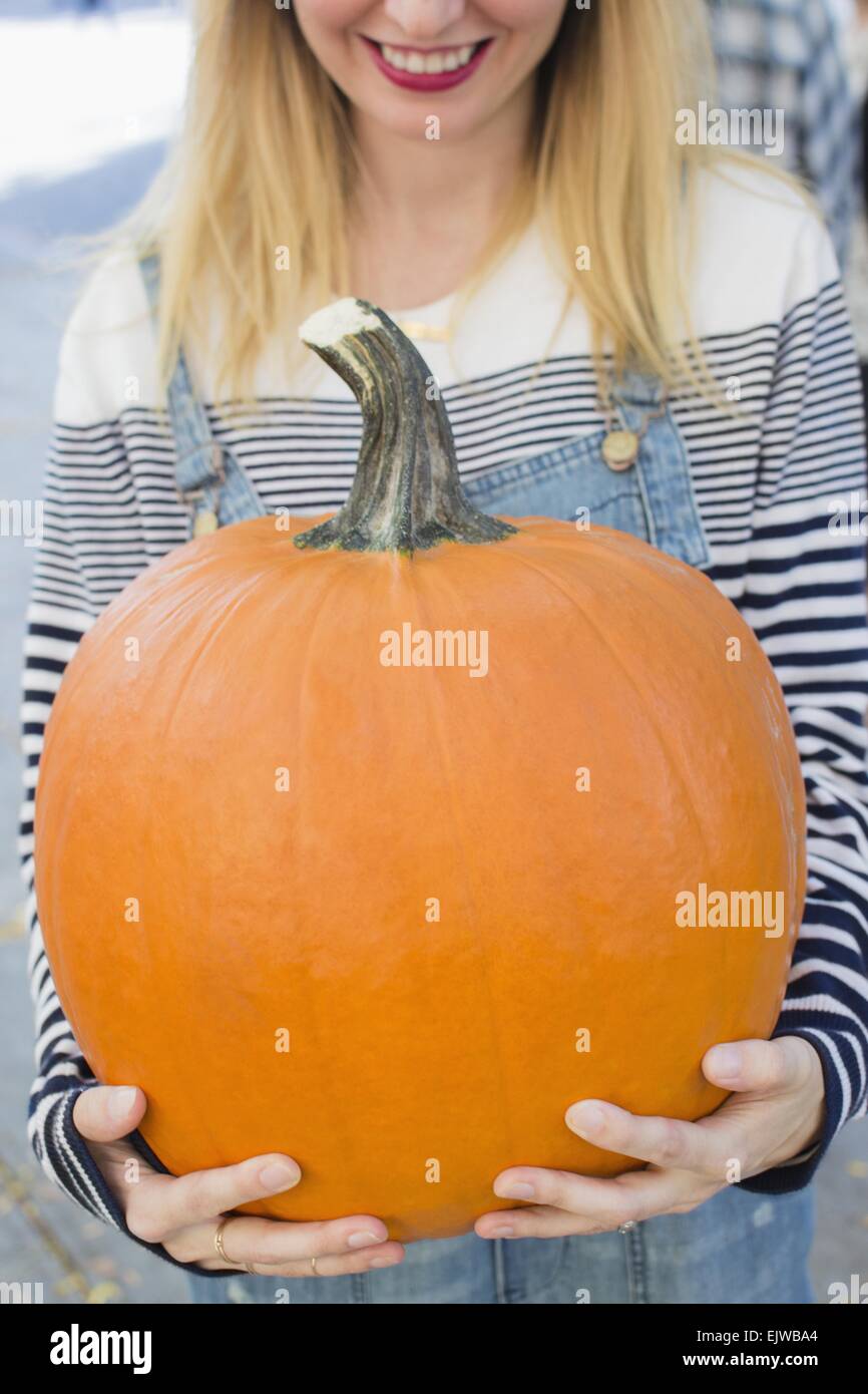 Mid-section of woman showing pumpkin Stock Photo - Alamy