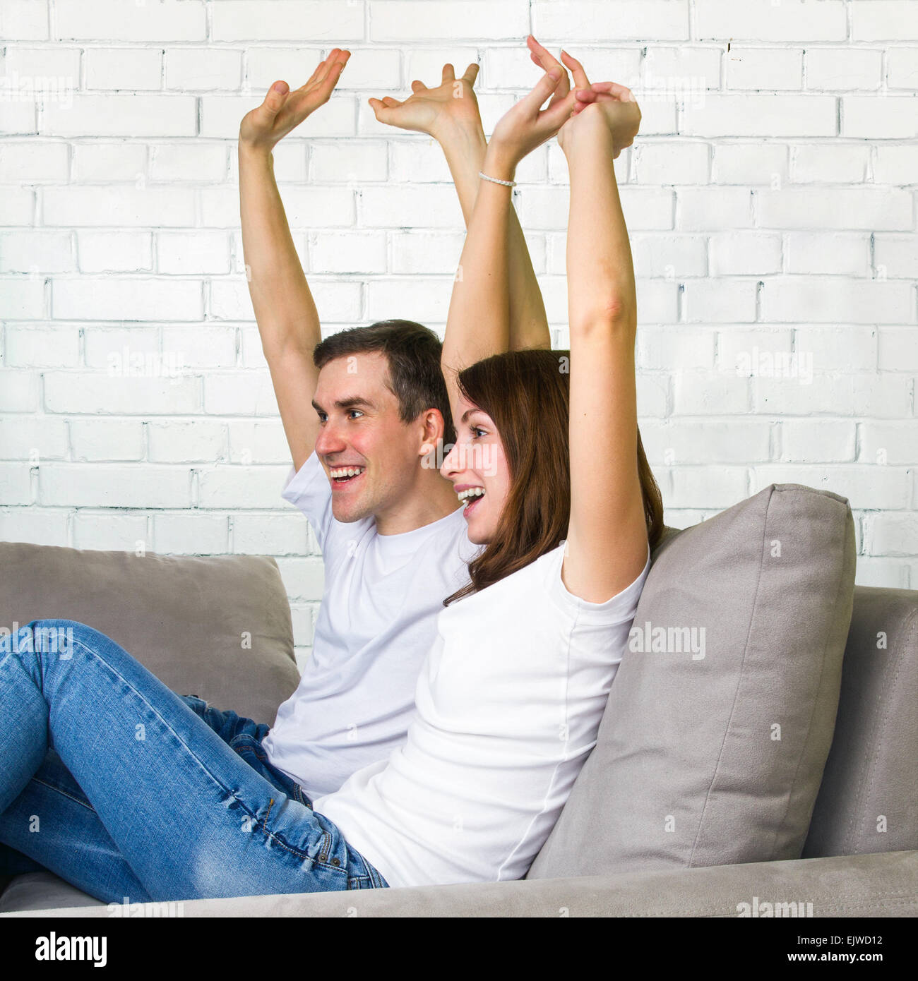 Happy couple with arms raised up Stock Photo - Alamy