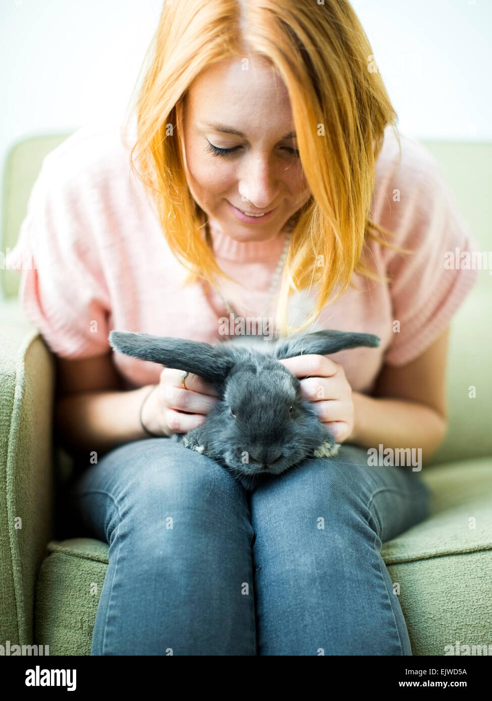 Woman stroking rabbit Stock Photo - Alamy