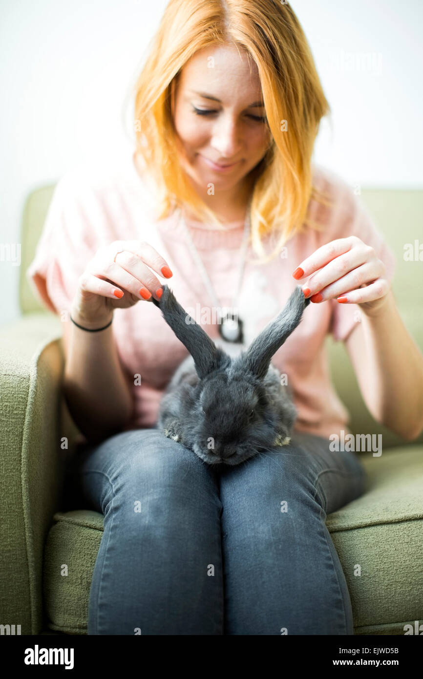 Woman touching rabbit's ears Stock Photo - Alamy