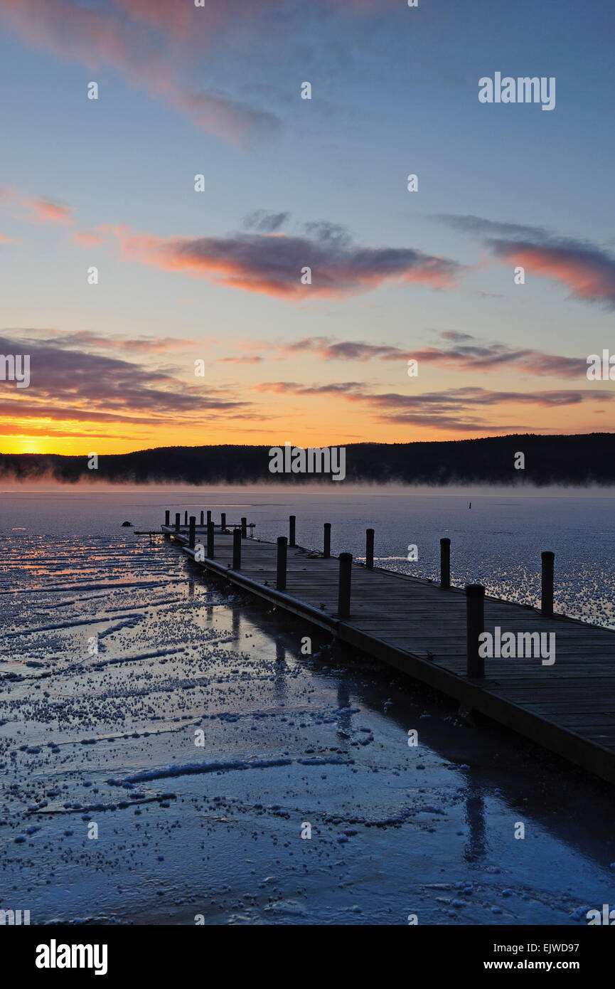 USA, New York, Lake George, Jetty on frozen lake, hills in background ...