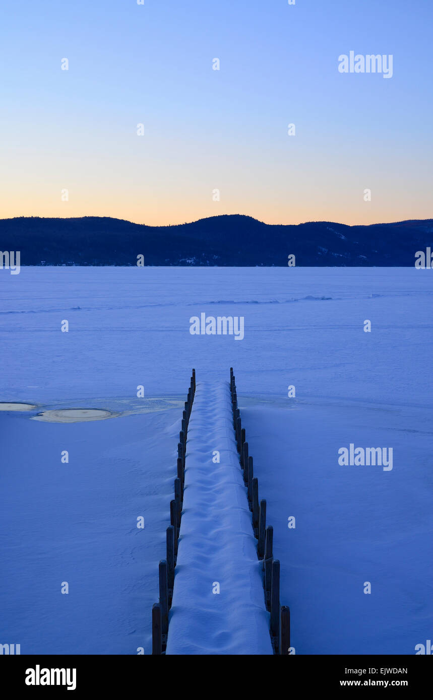 USA, New York, Lake George, Symmetrical image of snowed jetty with ...