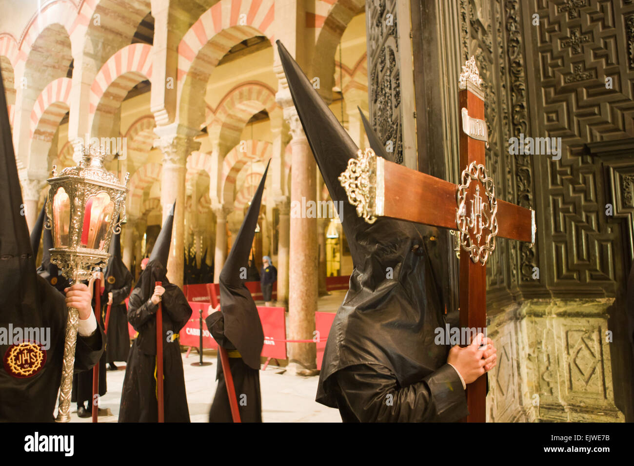 Easter nazarenes in black robe waiting inside the Mosque of Cordoba ...