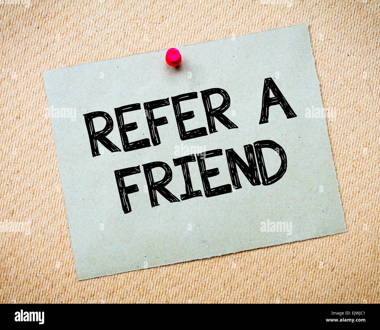 Recycled paper note pinned on cork board. Refer a Friend Message ...