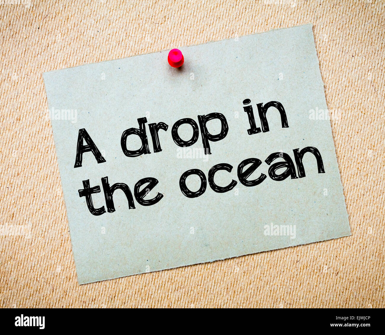 A drop in the ocean Message. Recycled paper note pinned on cork board ...