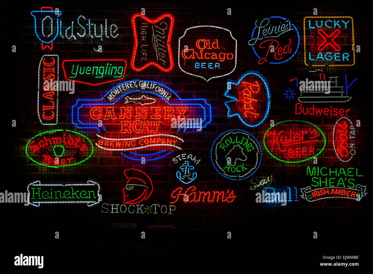 Neon signs light up and advertise the many brands of beer sold at a bar ...