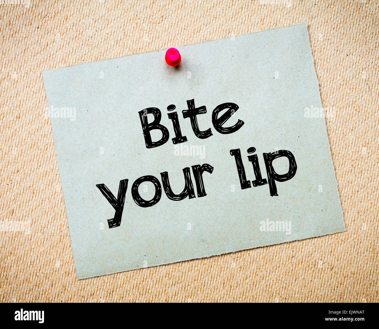 Bite your lip Message. Recycled paper note pinned on cork board ...