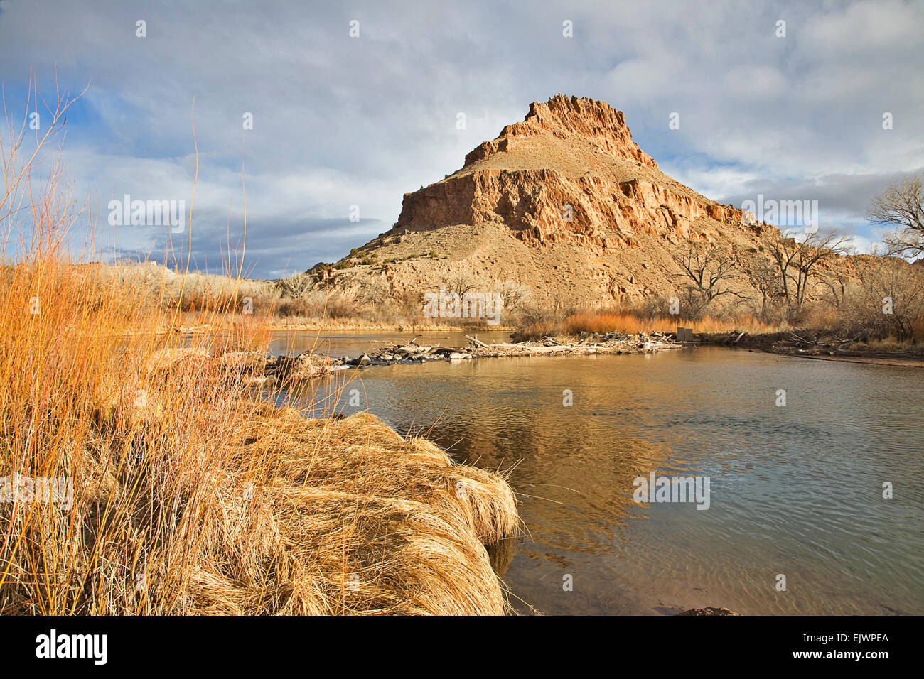The Chama River flows beneath rugged cliffs of colored earth near the ...