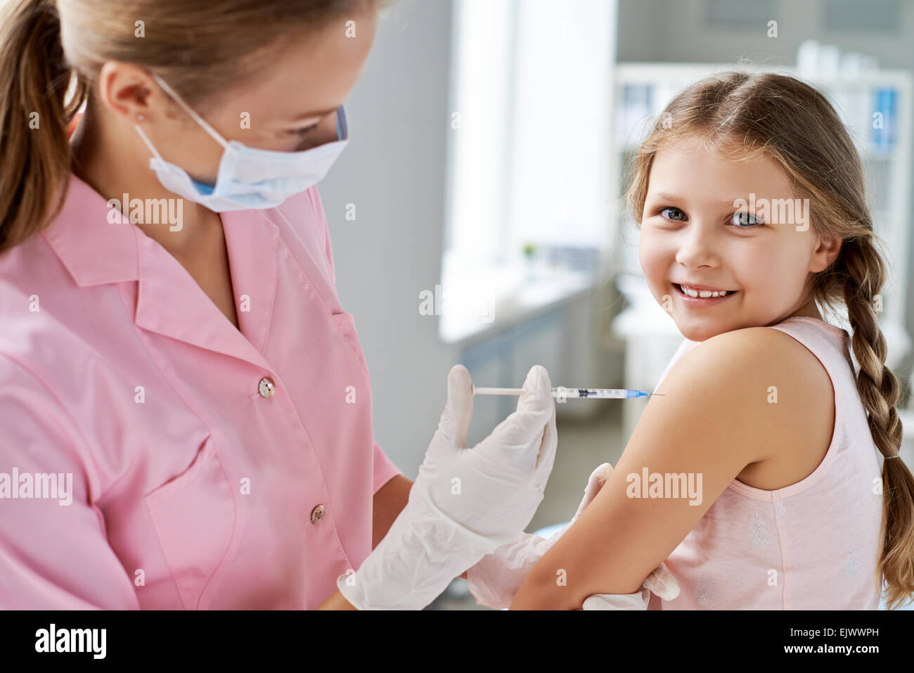 Nurse making injection to cute girl Stock Photo - Alamy