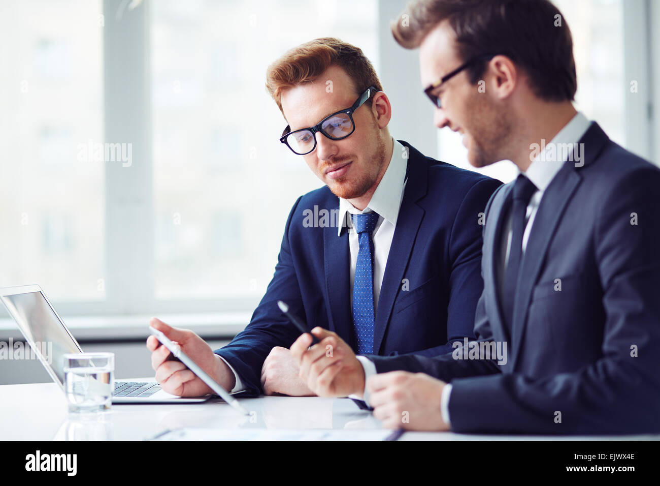 Young businessmen learning data upon new project at meeting Stock Photo ...